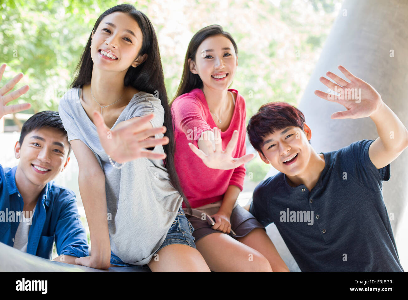 Three friends sitting waving camera hi-res stock photography and images ...