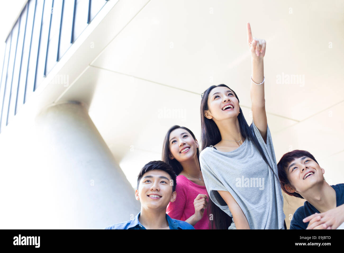 Standing smiling looking away arms up building exterior hi-res stock ...