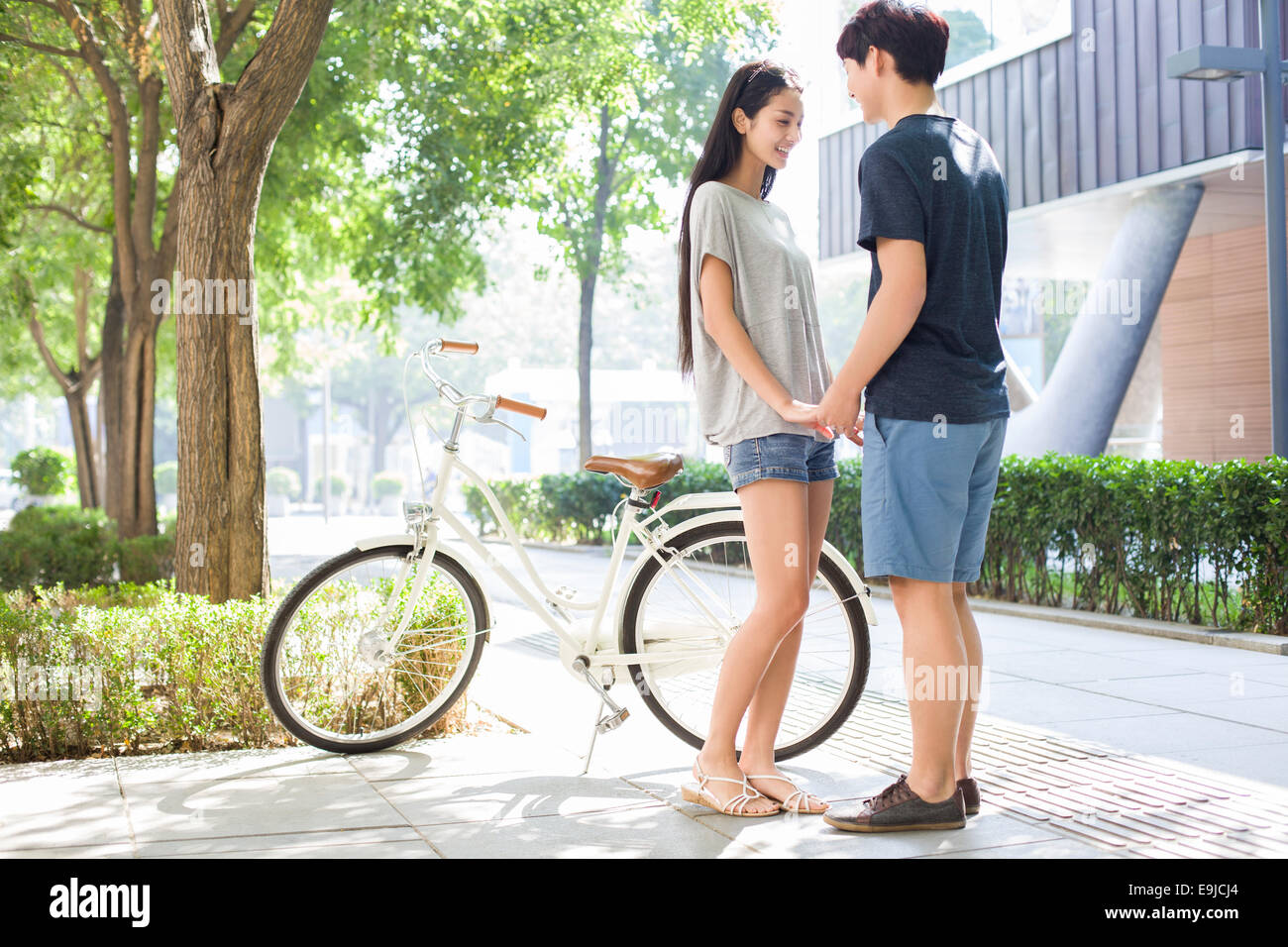 Young couple dating at campus with bicycle Stock Photo - Alamy