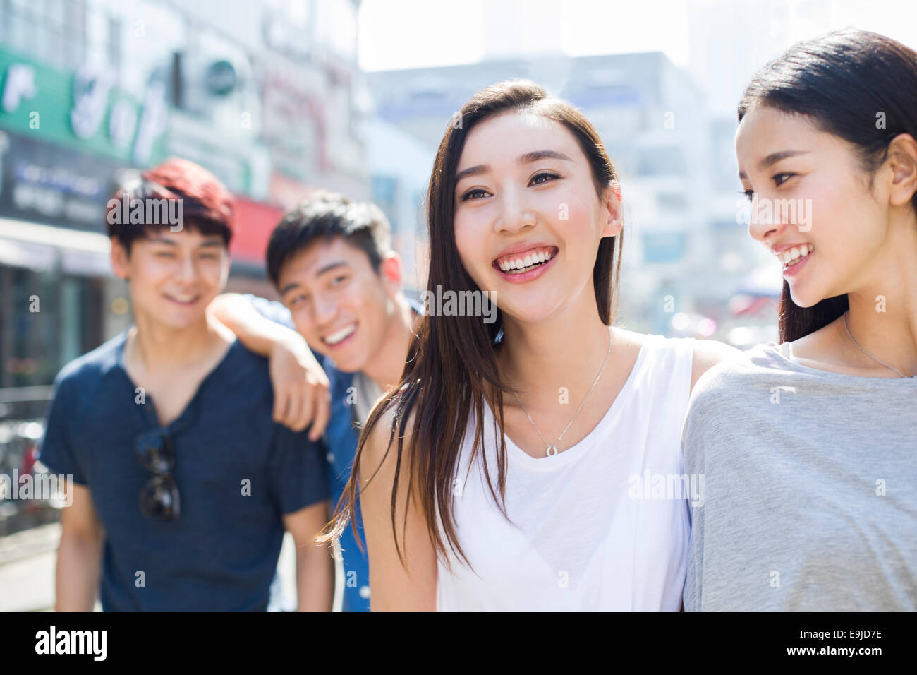 College friends walking on street hi-res stock photography and images ...