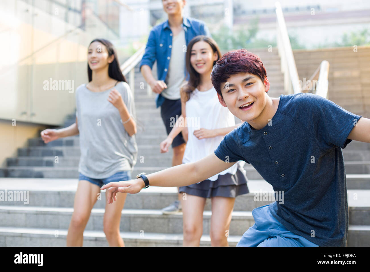 Young man sliding down banister on steps Stock Photo - Alamy