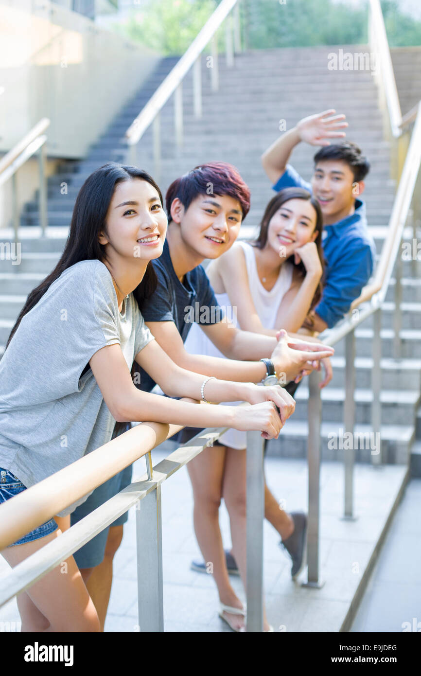 Happy young woman standing together with her friends Stock Photo - Alamy