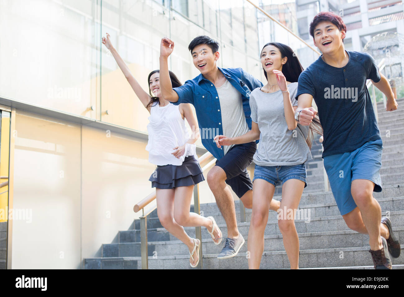 Young friends running down steps Stock Photo - Alamy