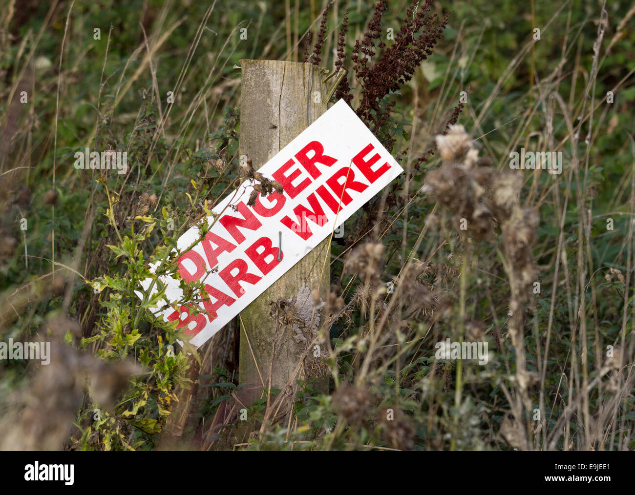 Danger barb wire sign on post Stock Photo - Alamy