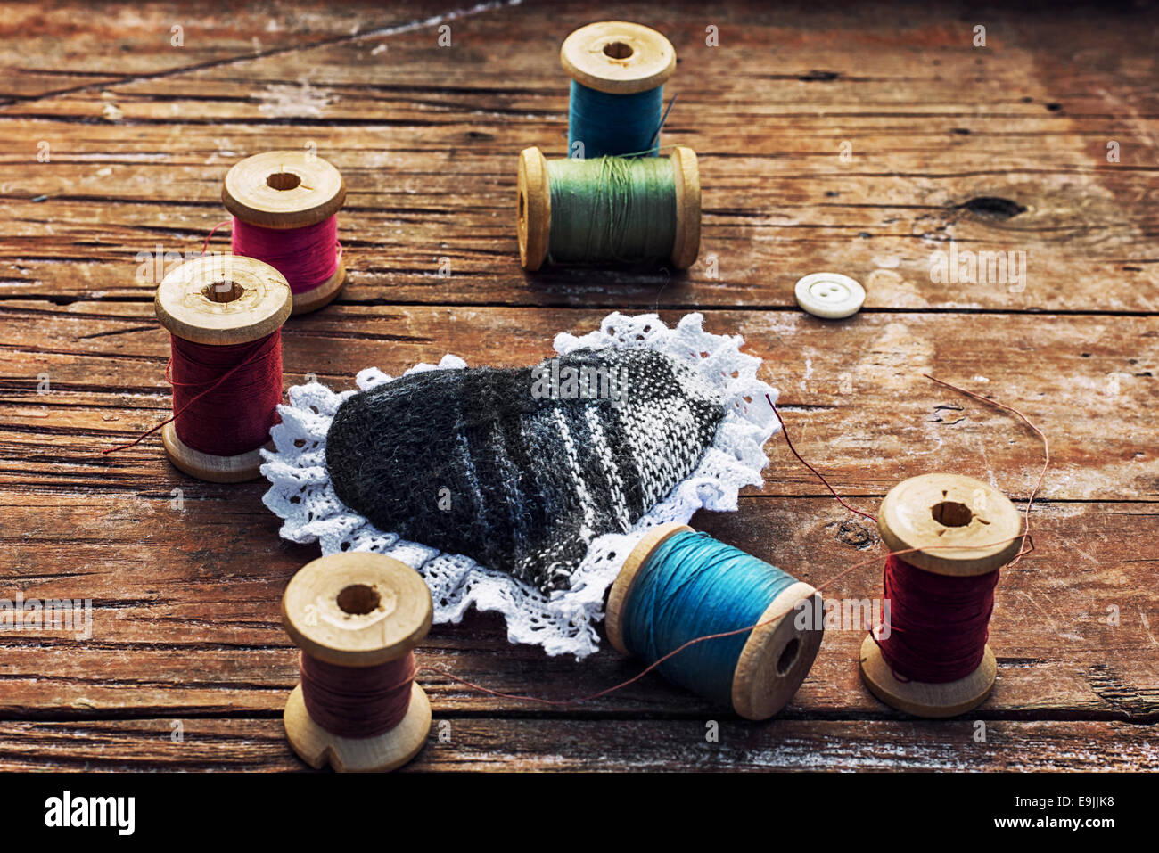 set of threads of different types,colors and lengths on wooden ...