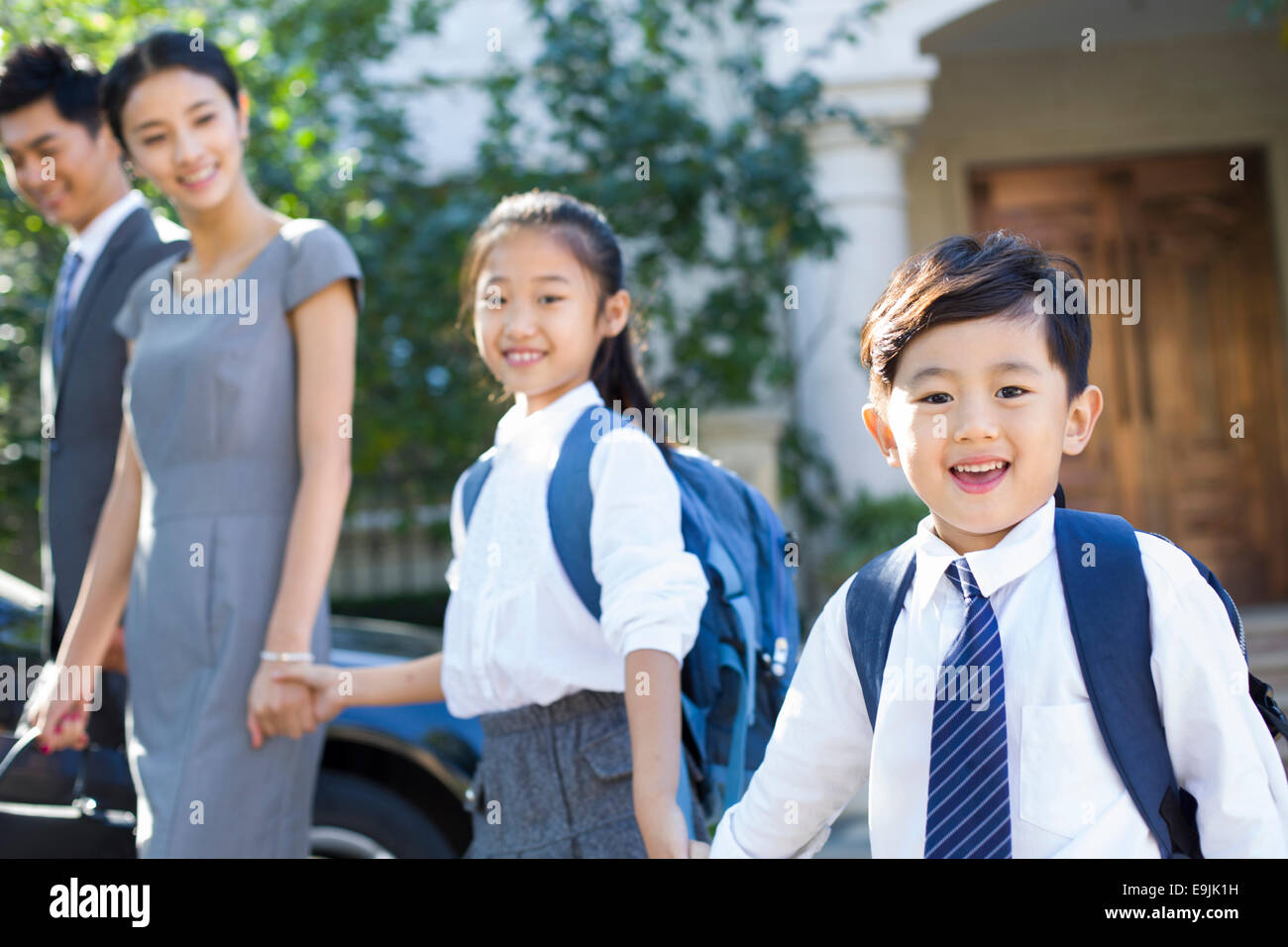 Young couple sending their children to school Stock Photo - Alamy