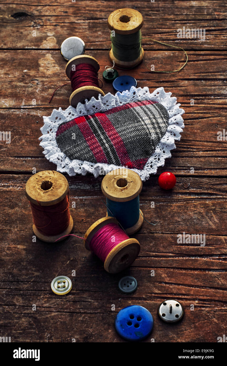 set of threads of different types,colors and lengths on wooden ...