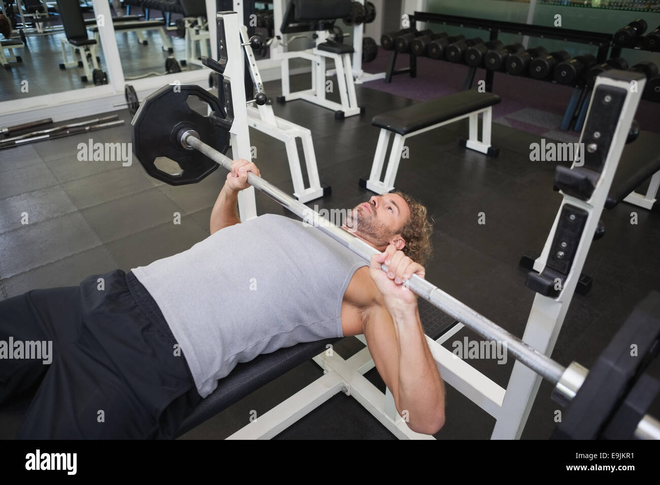 Young muscular man lifting barbell in gym Stock Photo - Alamy