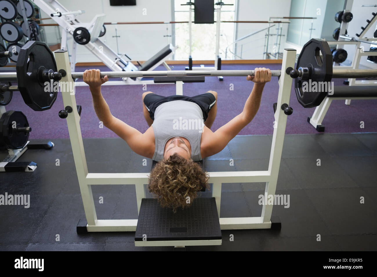 Young muscular man lifting barbell in gym Stock Photo - Alamy