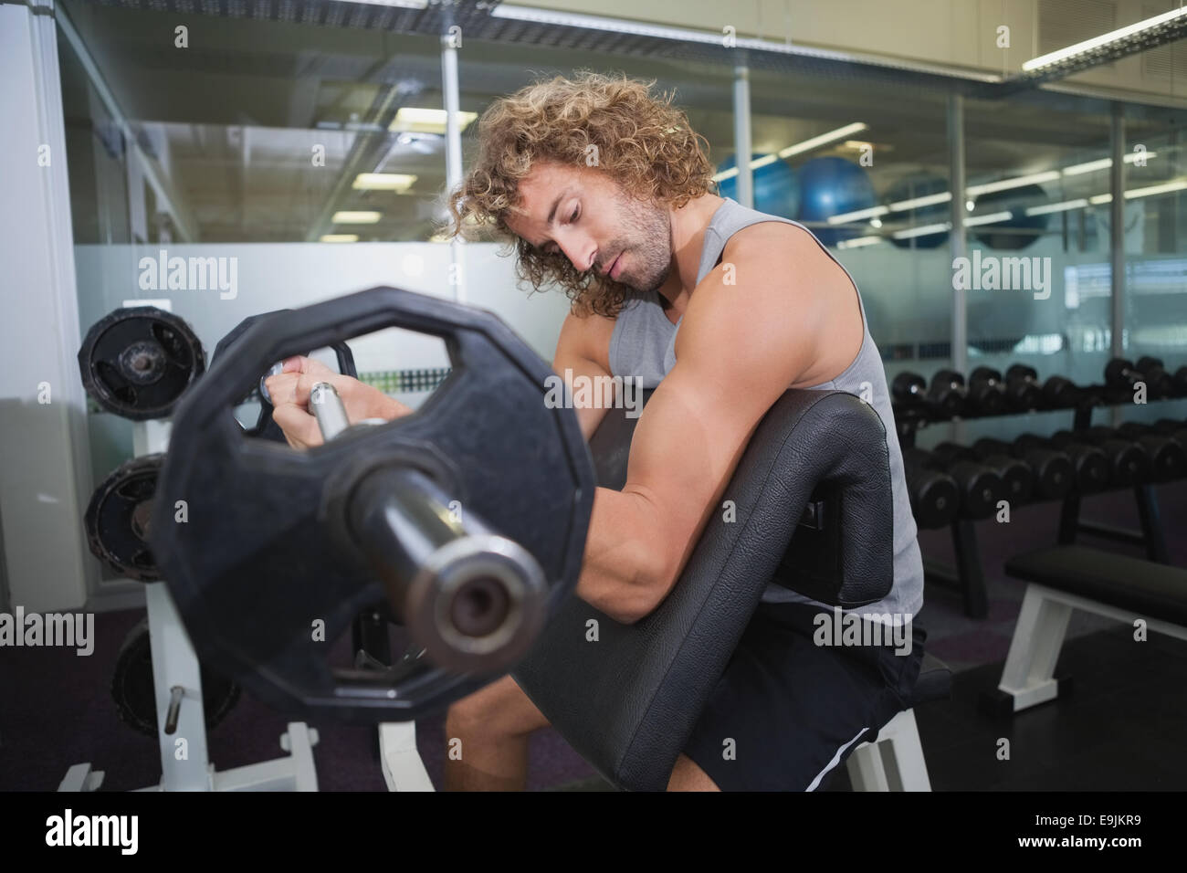 Side view of muscular man lifting barbell in gym Stock Photo - Alamy