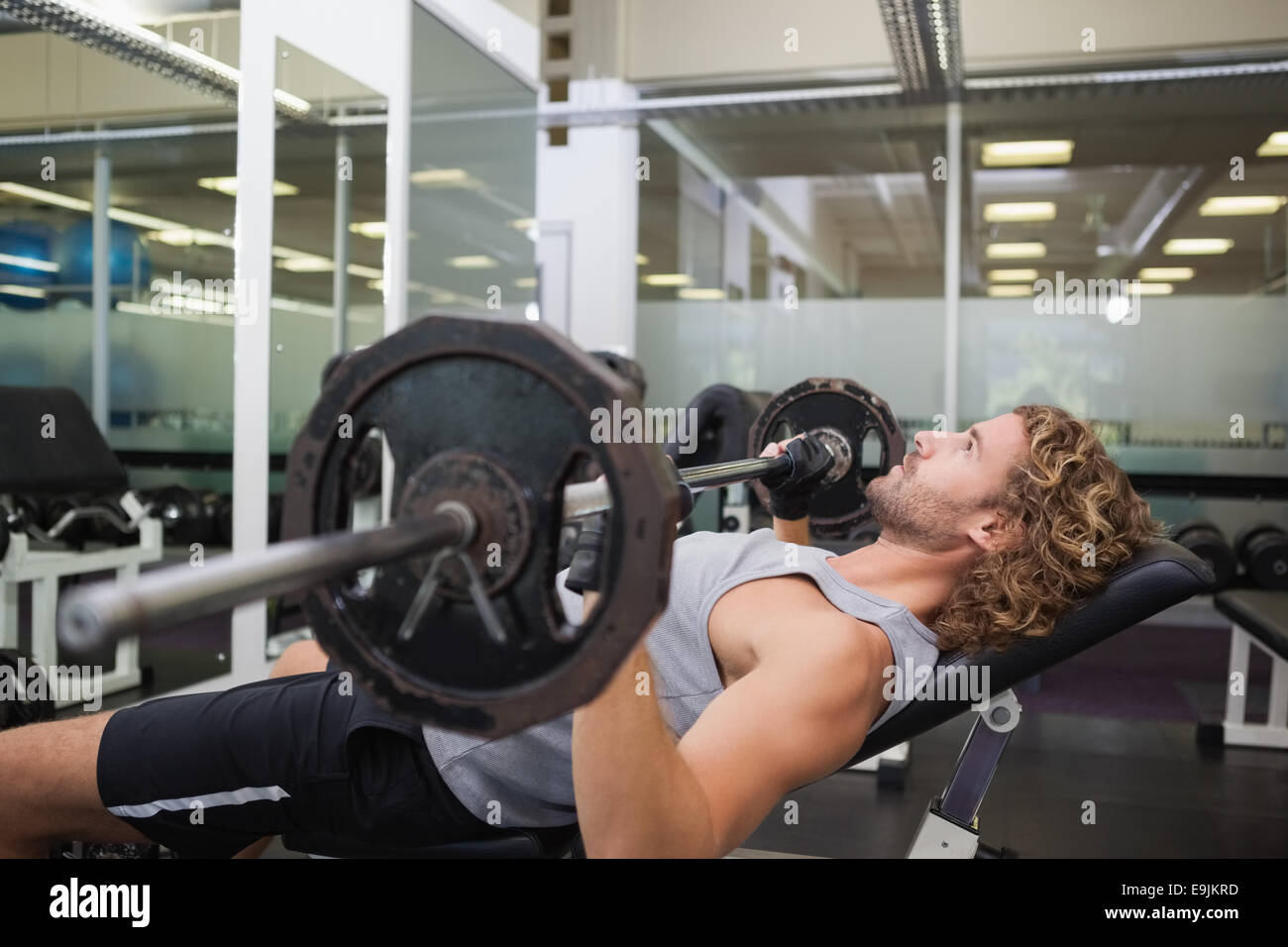 Side view of muscular man lifting barbell in gym Stock Photo - Alamy
