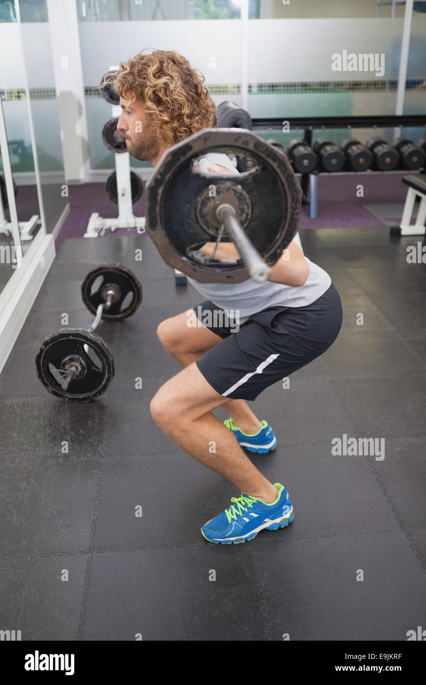Side view of muscular man lifting barbell in gym Stock Photo - Alamy