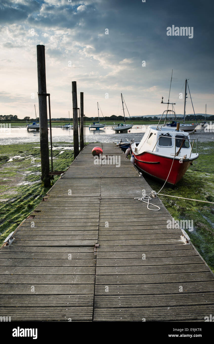 Boat a low tide moored to harbor jetty landscape Stock Photo - Alamy