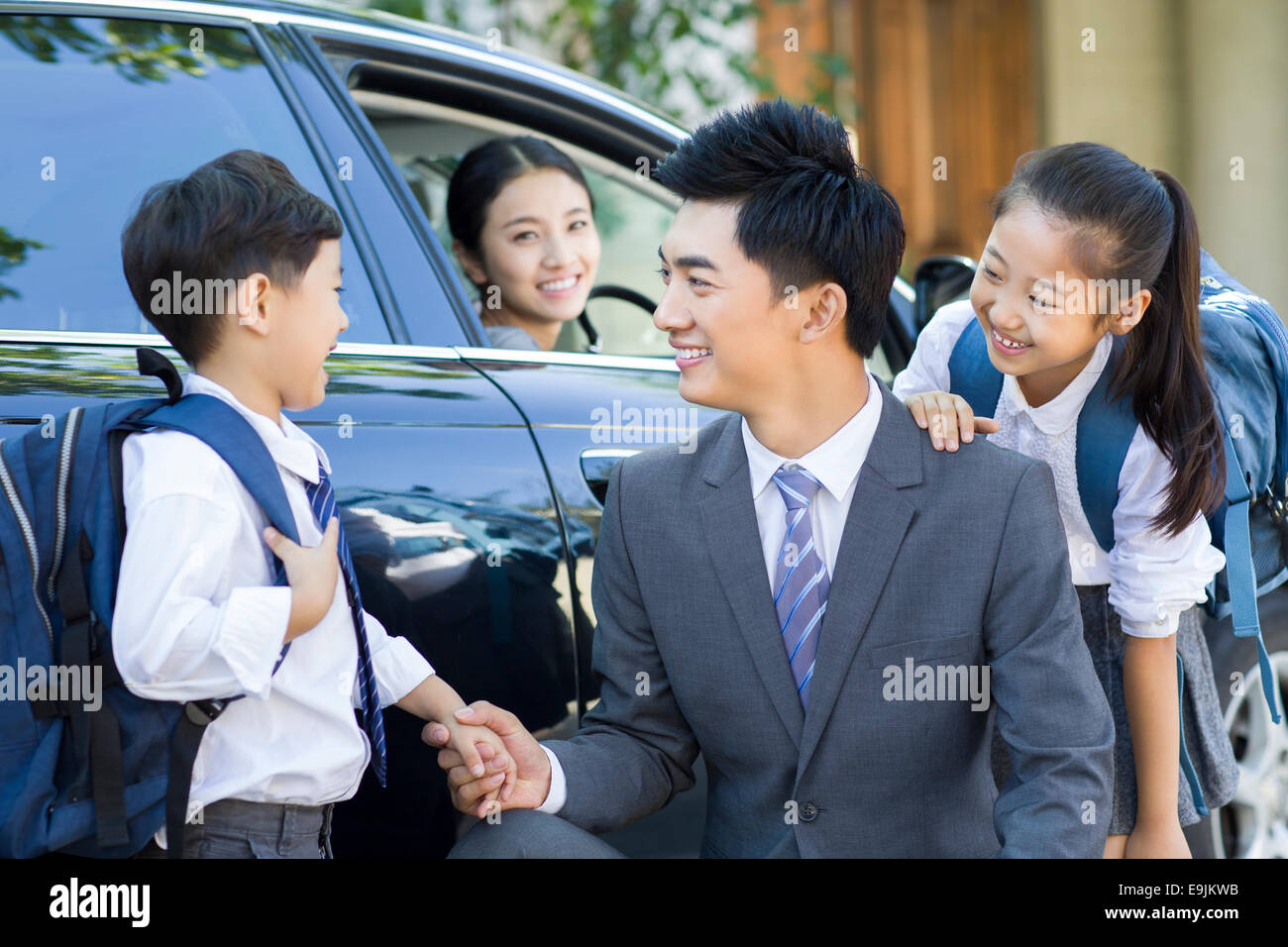 Young couple sending their children to school Stock Photo - Alamy