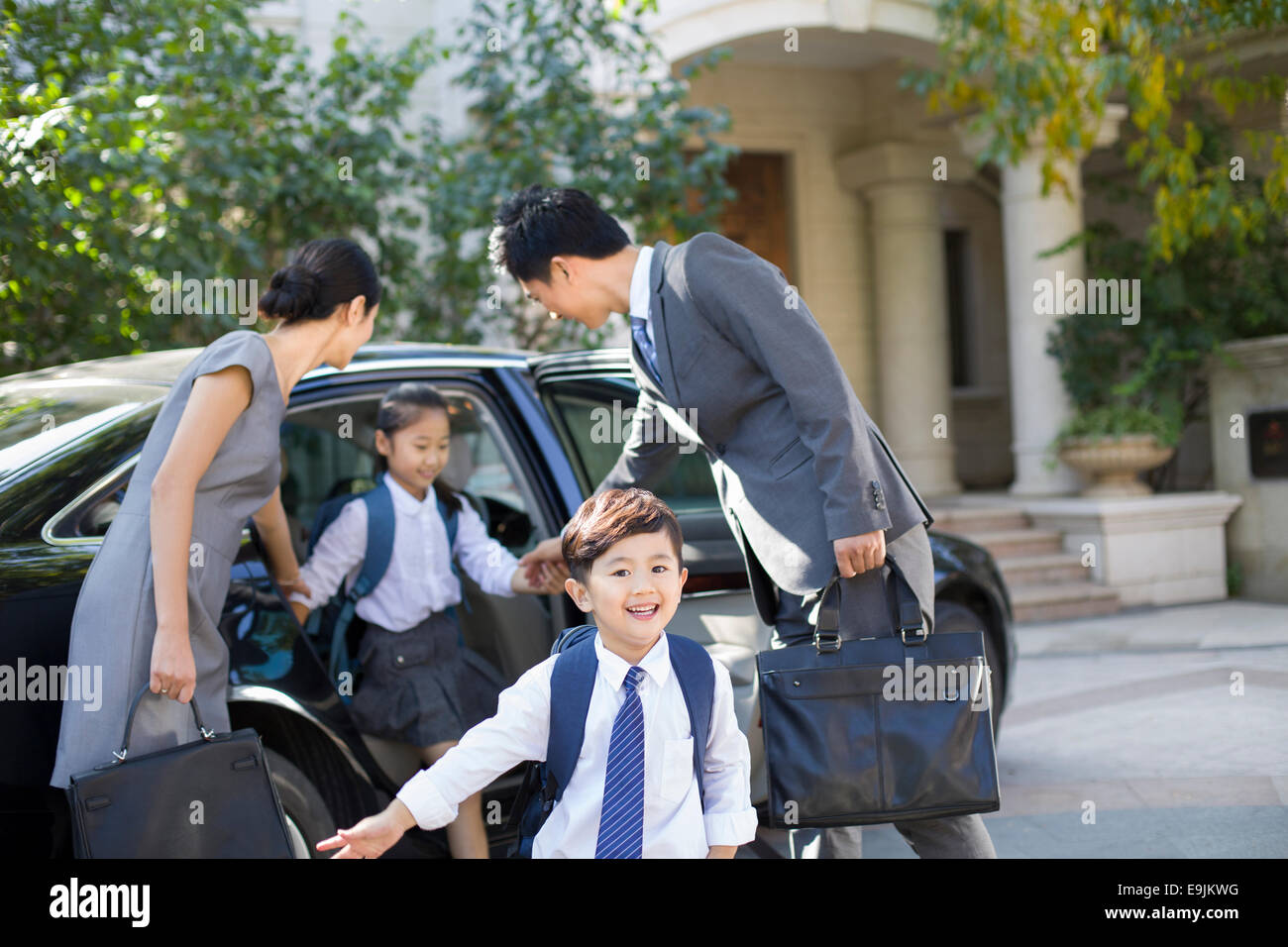 Young couple bringing their children back from school Stock Photo - Alamy