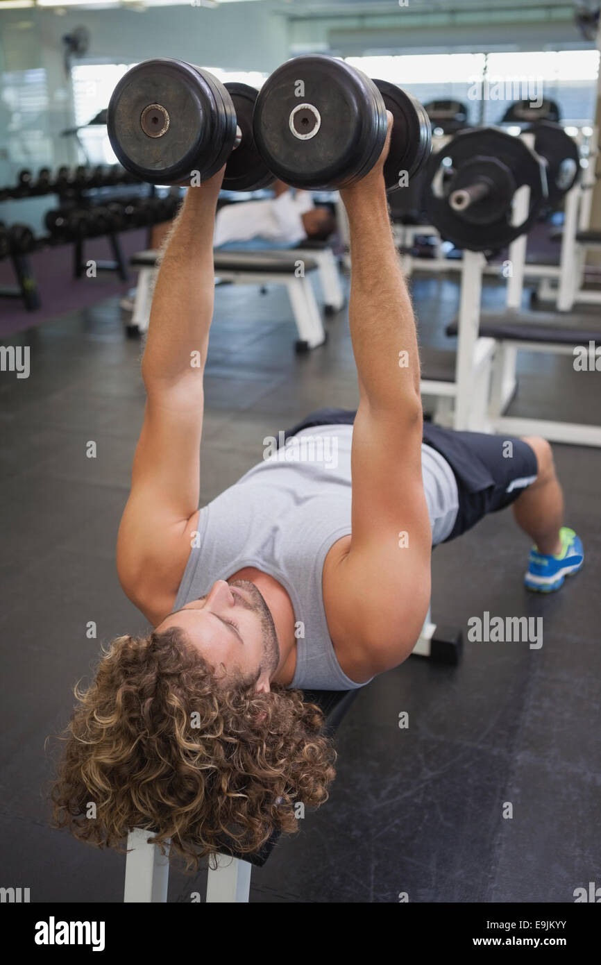 Young man exercising with dumbbells in gym Stock Photo - Alamy