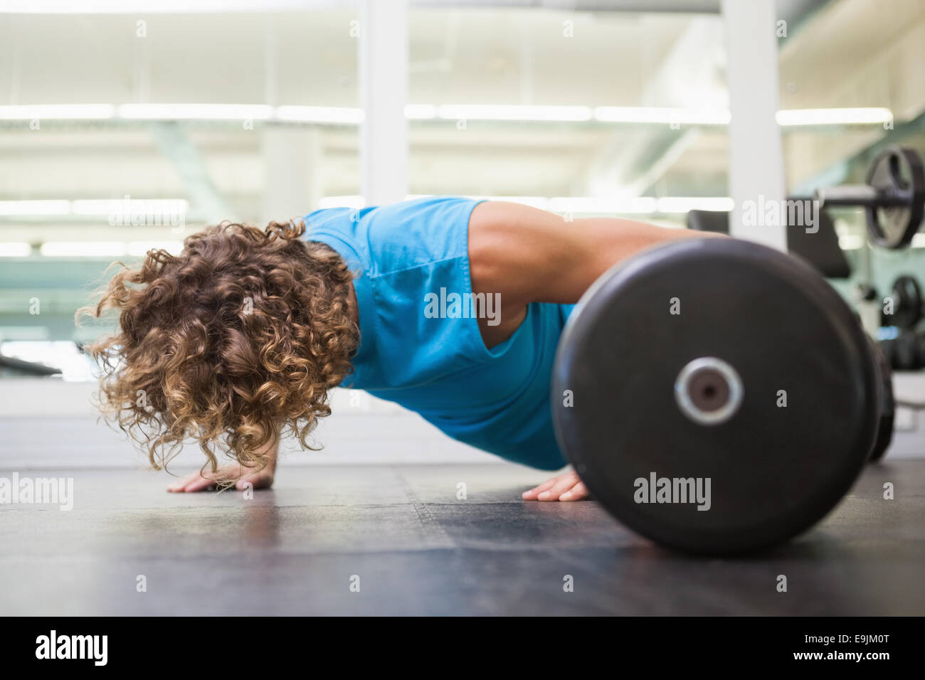 Side view of young man doing push ups in gym Stock Photo - Alamy