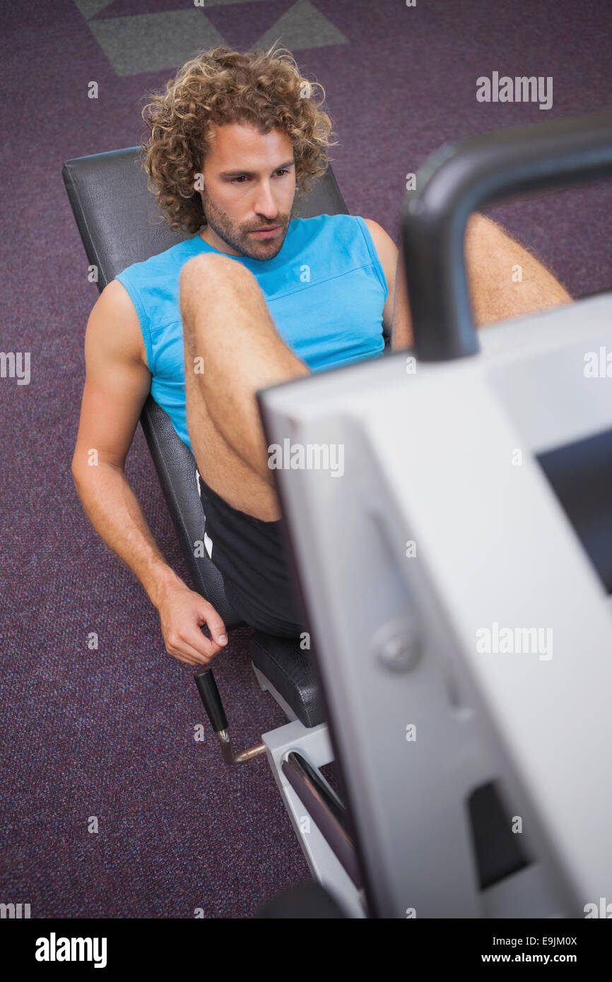 Handsome man doing leg presses in gym Stock Photo - Alamy