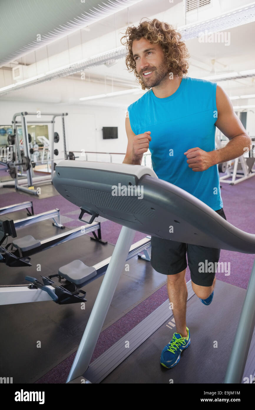 Smiling man running on treadmill in gym Stock Photo - Alamy