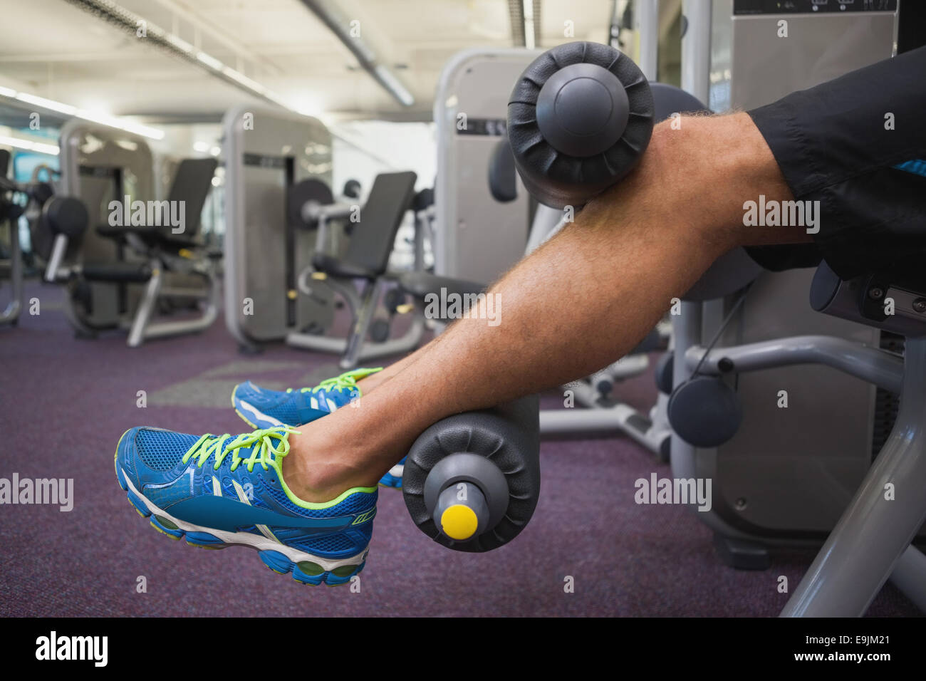 Low section of man doing leg workout at gym Stock Photo - Alamy