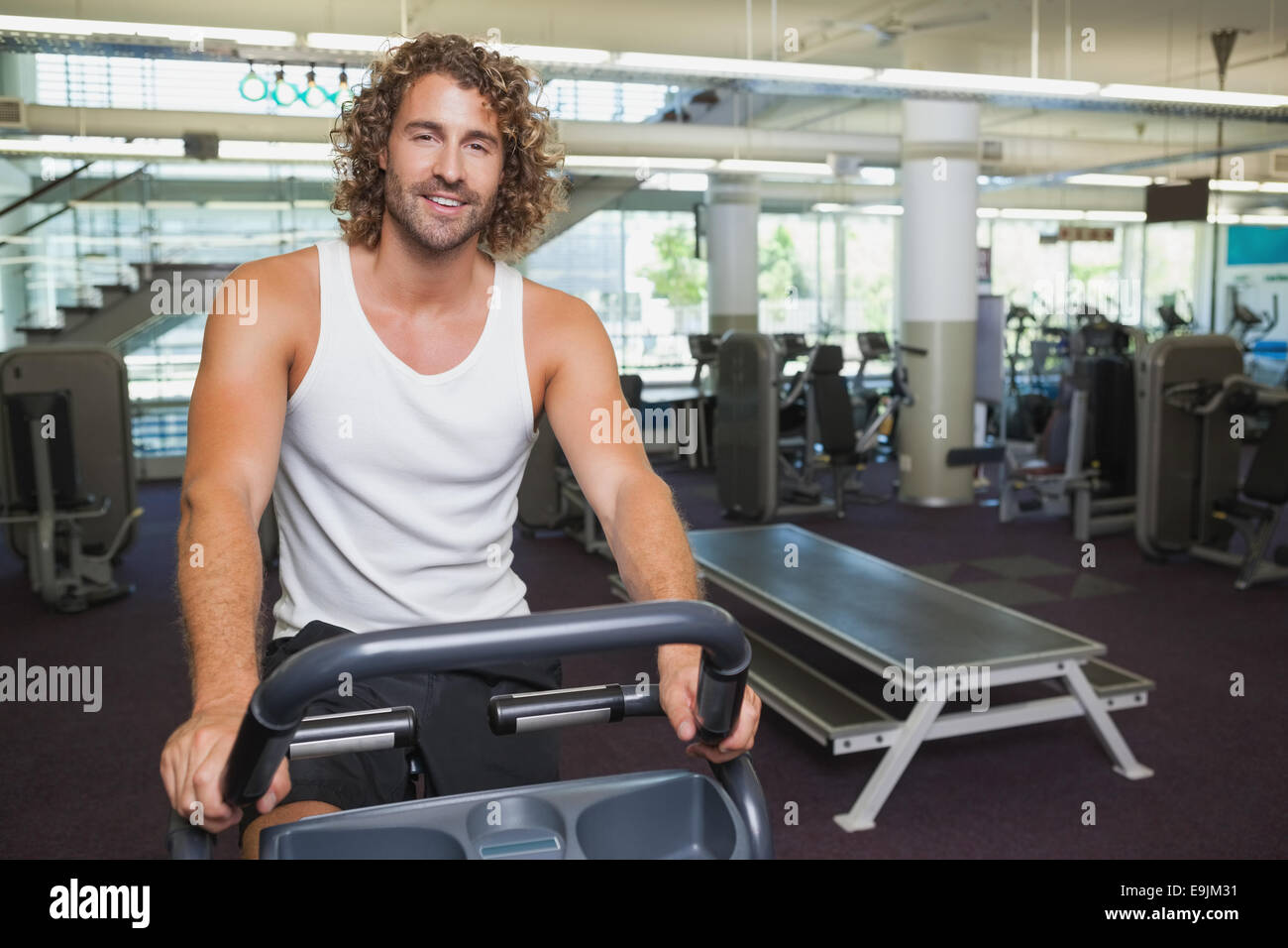 Handsome man working out on exercise bike at gym Stock Photo - Alamy