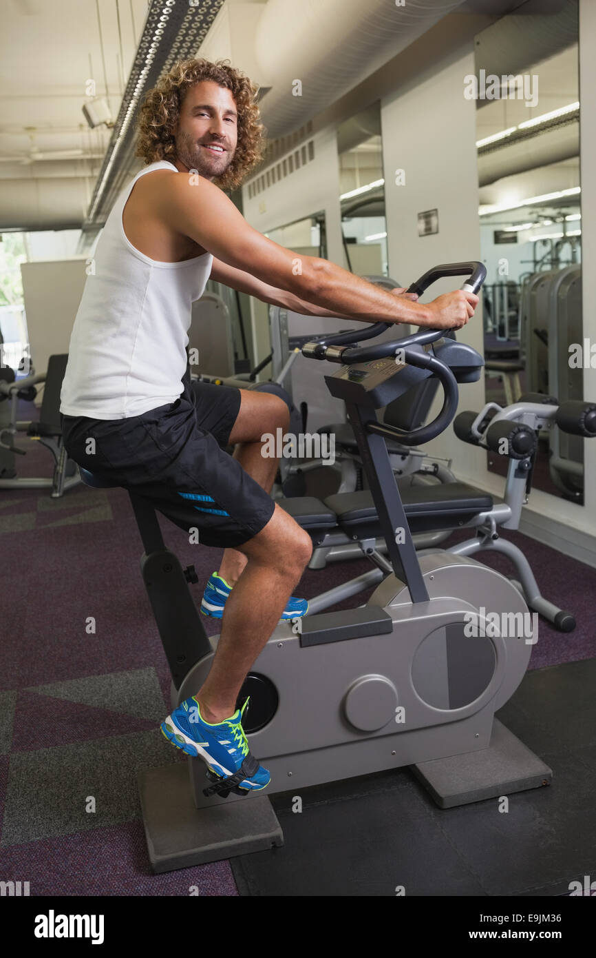 Side view of man working out on exercise bike at gym Stock Photo - Alamy