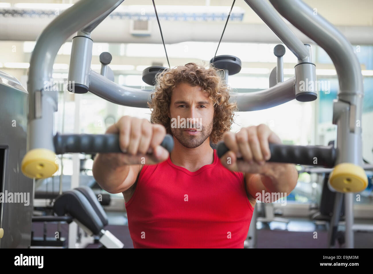 Handsome man working on fitness machine at gym Stock Photo - Alamy
