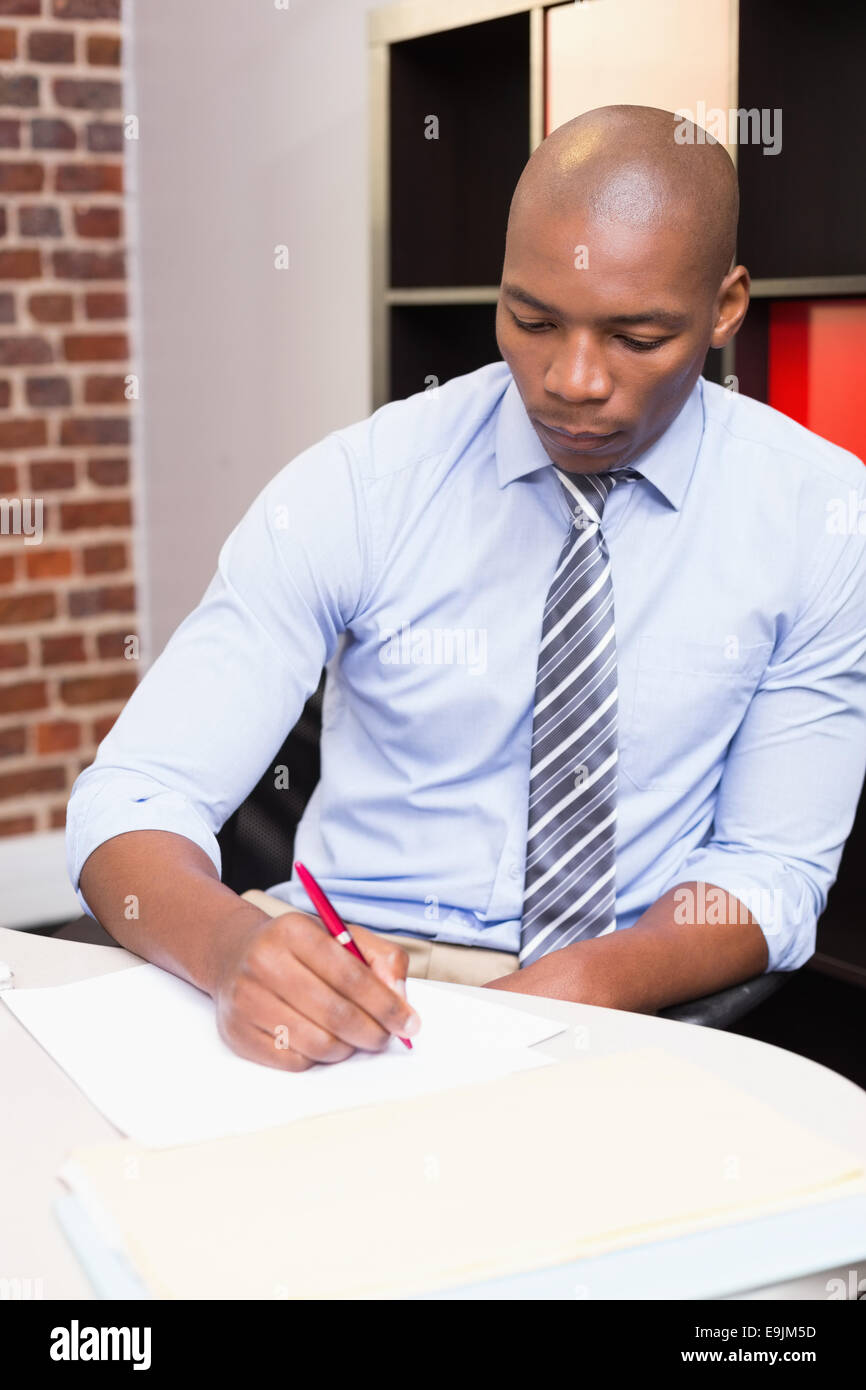 Businessman writing document at desk Stock Photo - Alamy