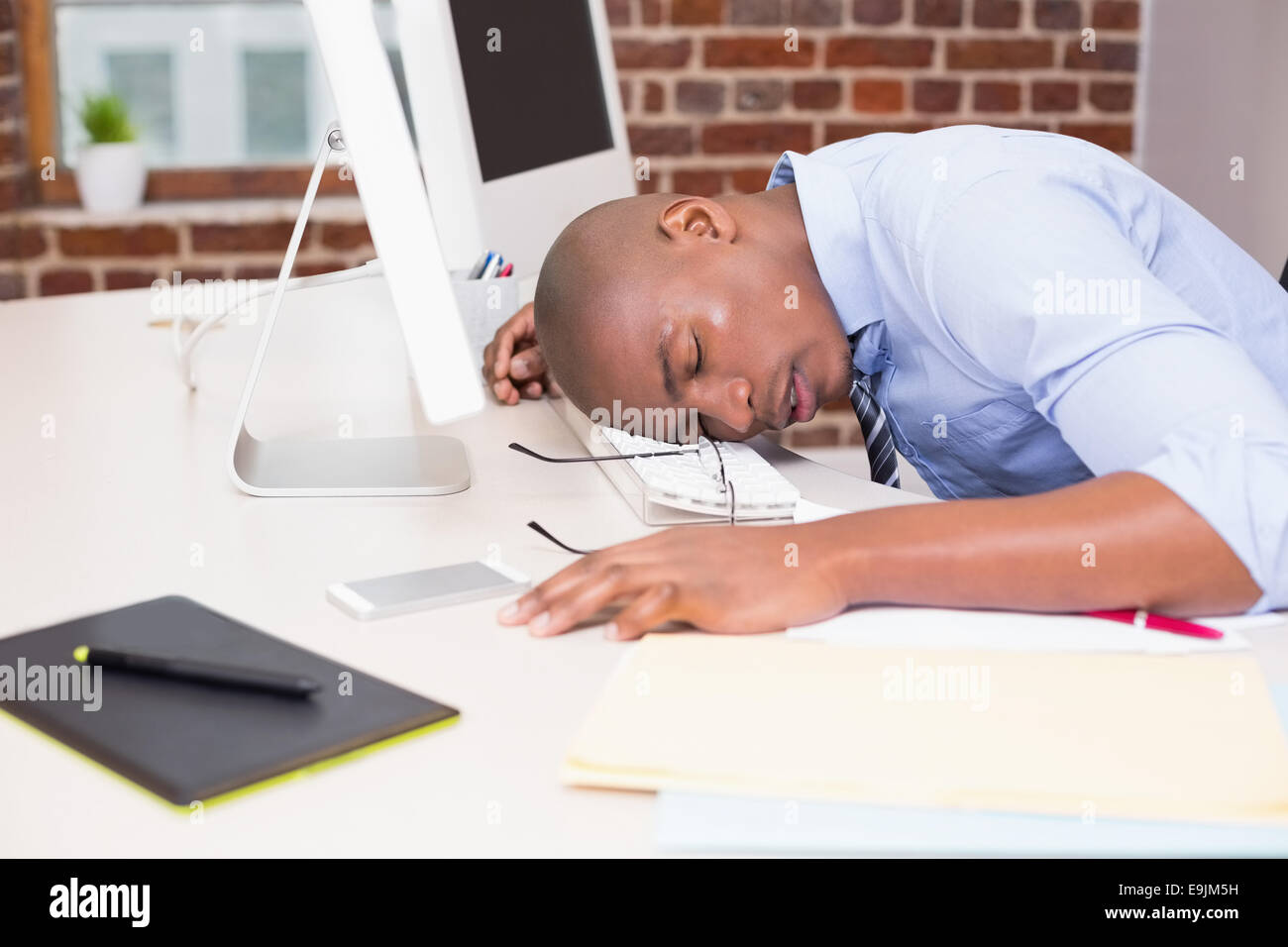 Businessman resting head on computer keyboard Stock Photo - Alamy