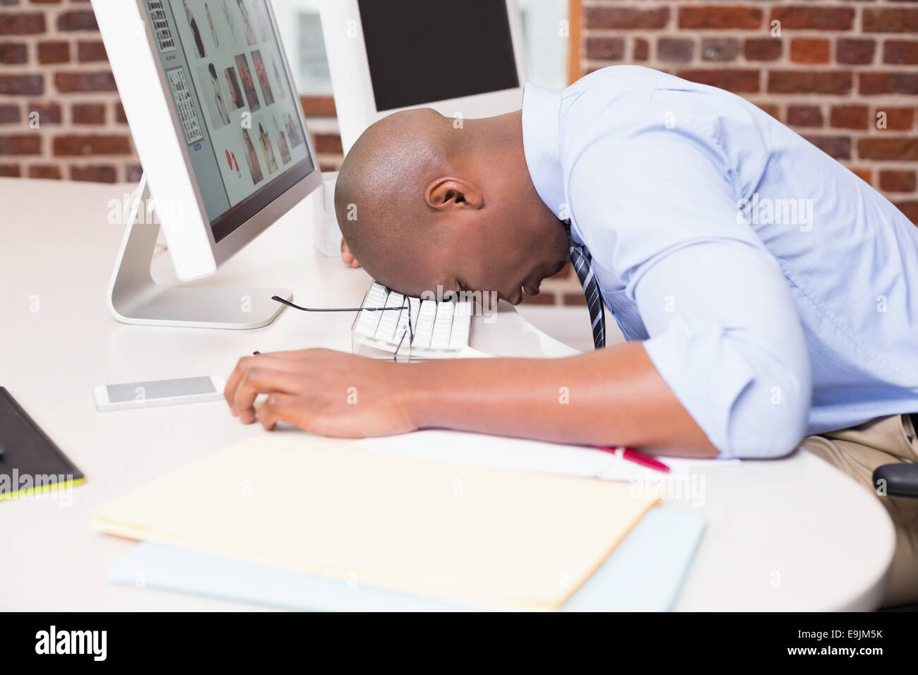 Businessman resting head on computer keyboard in office Stock Photo - Alamy
