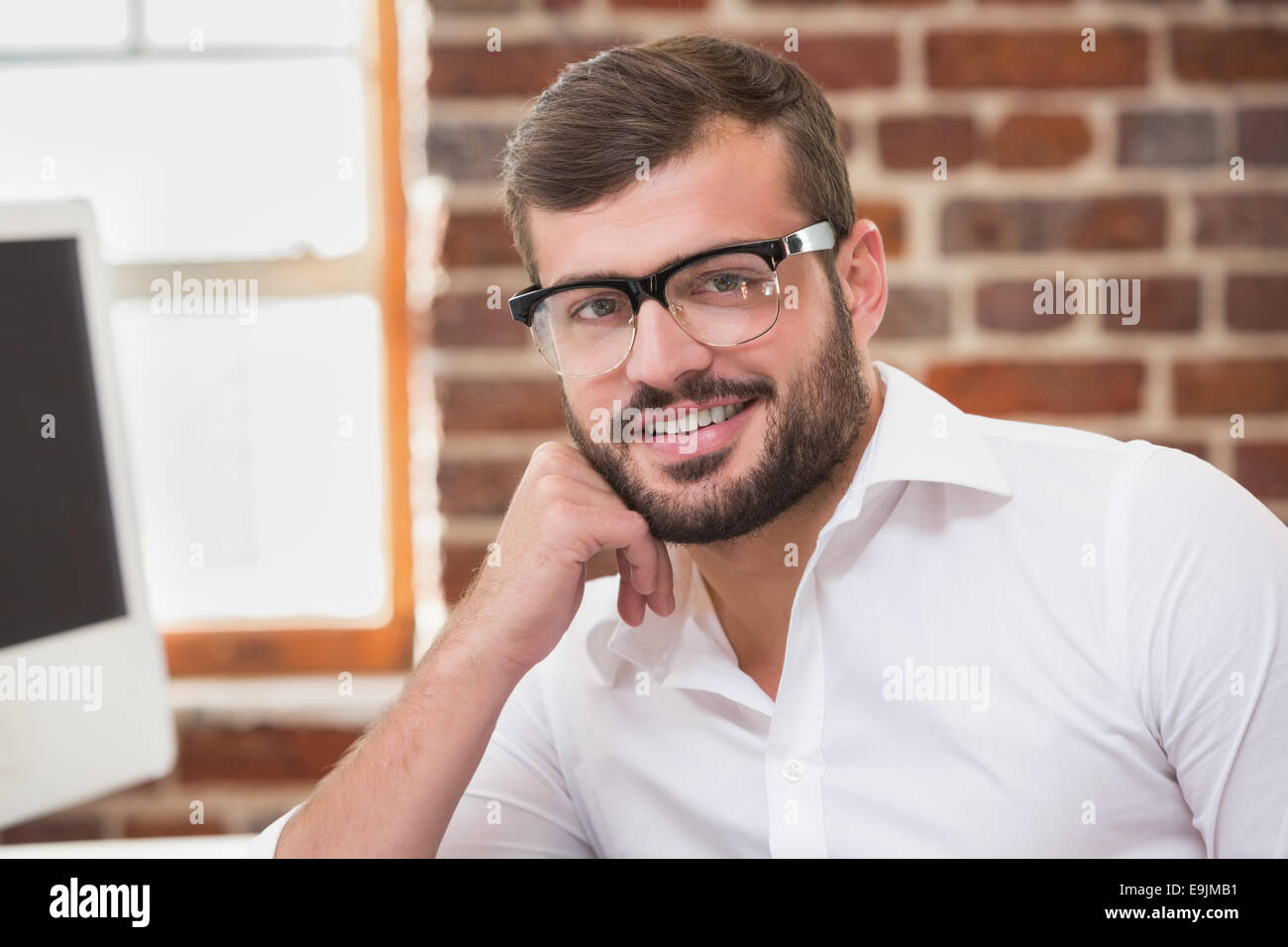 Smiling young businessman in office Stock Photo - Alamy