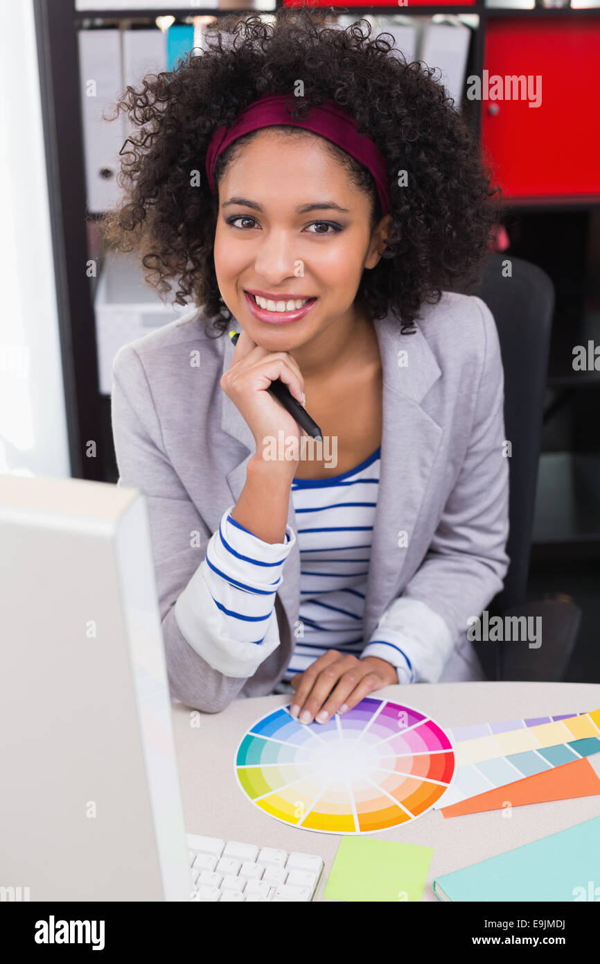 Smiling female photo editor at office desk Stock Photo - Alamy