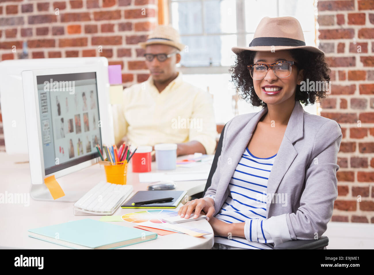Smiling female photo editor at office desk Stock Photo - Alamy