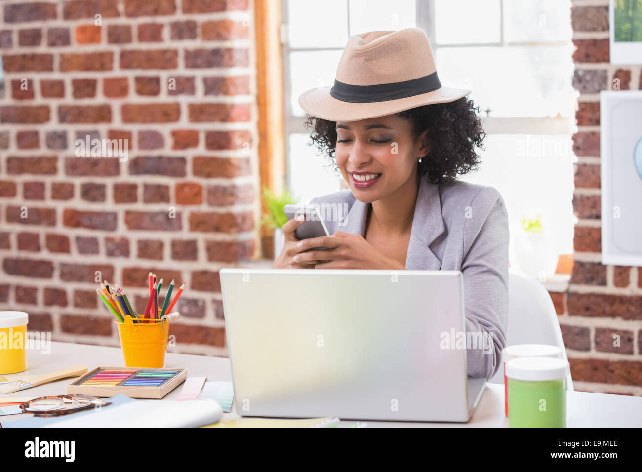 Interior designer text messaging in office Stock Photo - Alamy