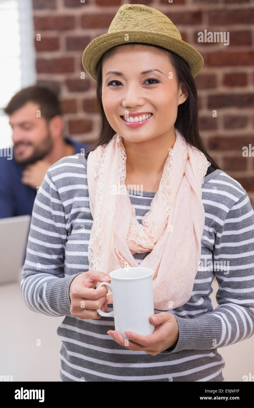 Casual woman with coffee cup in office Stock Photo - Alamy