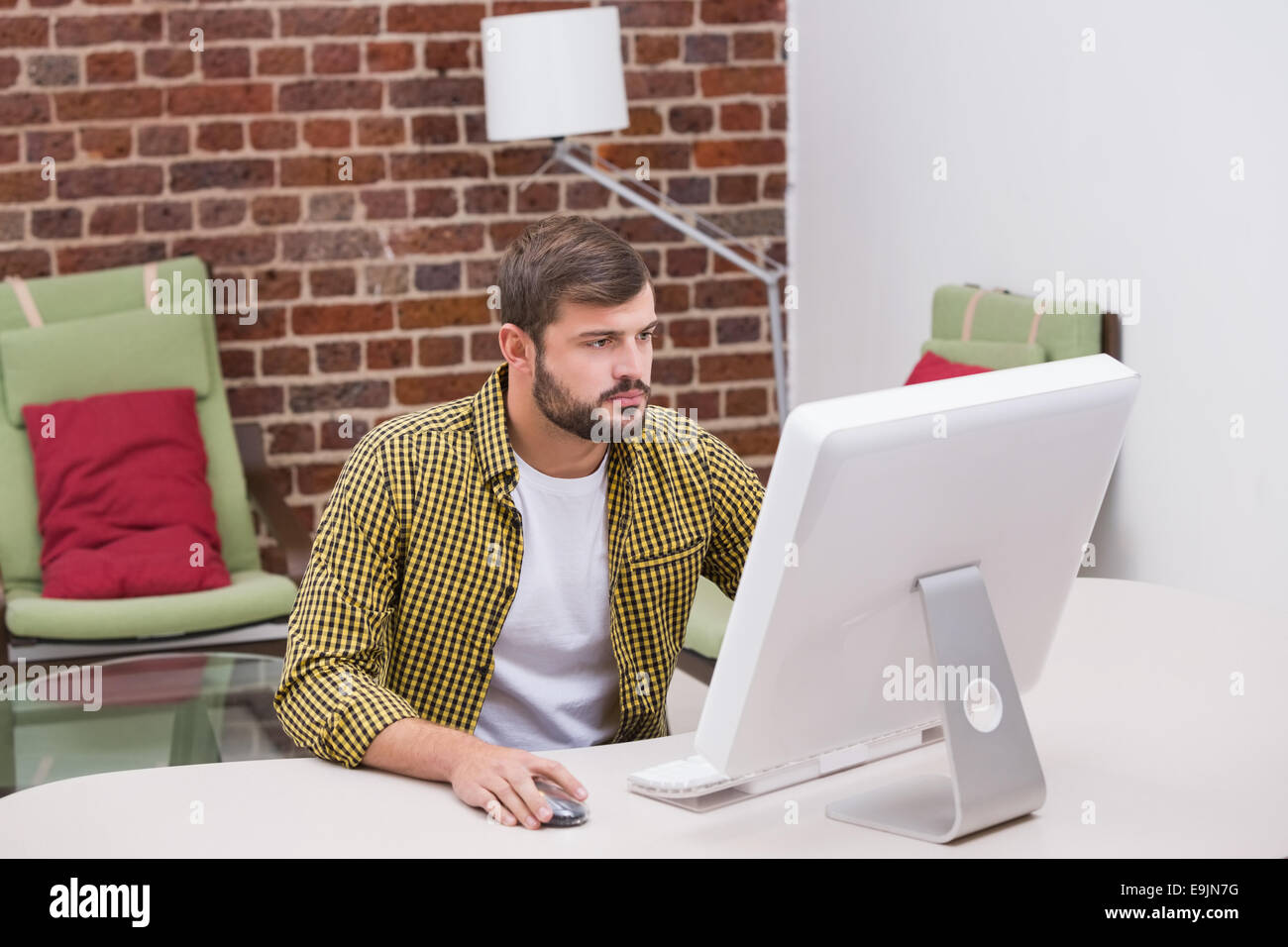 Serious casual young man using computer Stock Photo - Alamy