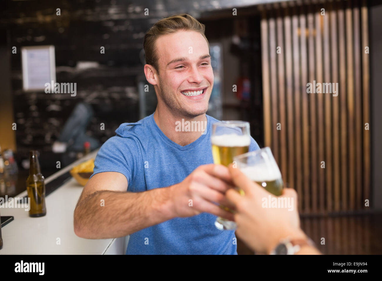 Young man toasting with pint of beer Stock Photo - Alamy