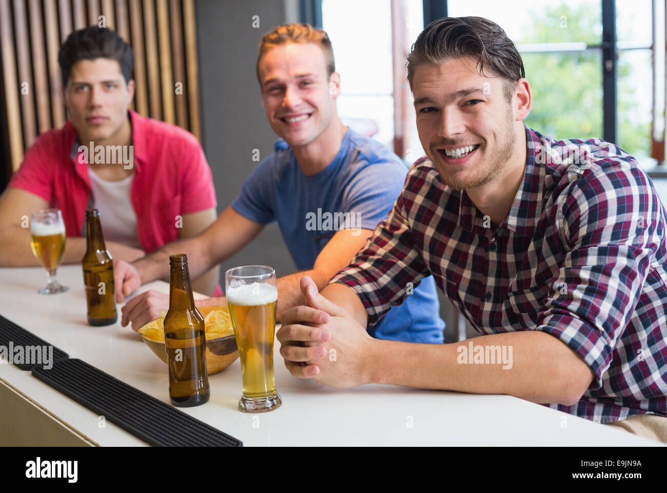 Young men drinking beer together Stock Photo - Alamy