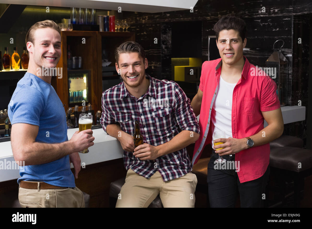 Young men drinking beer together Stock Photo - Alamy