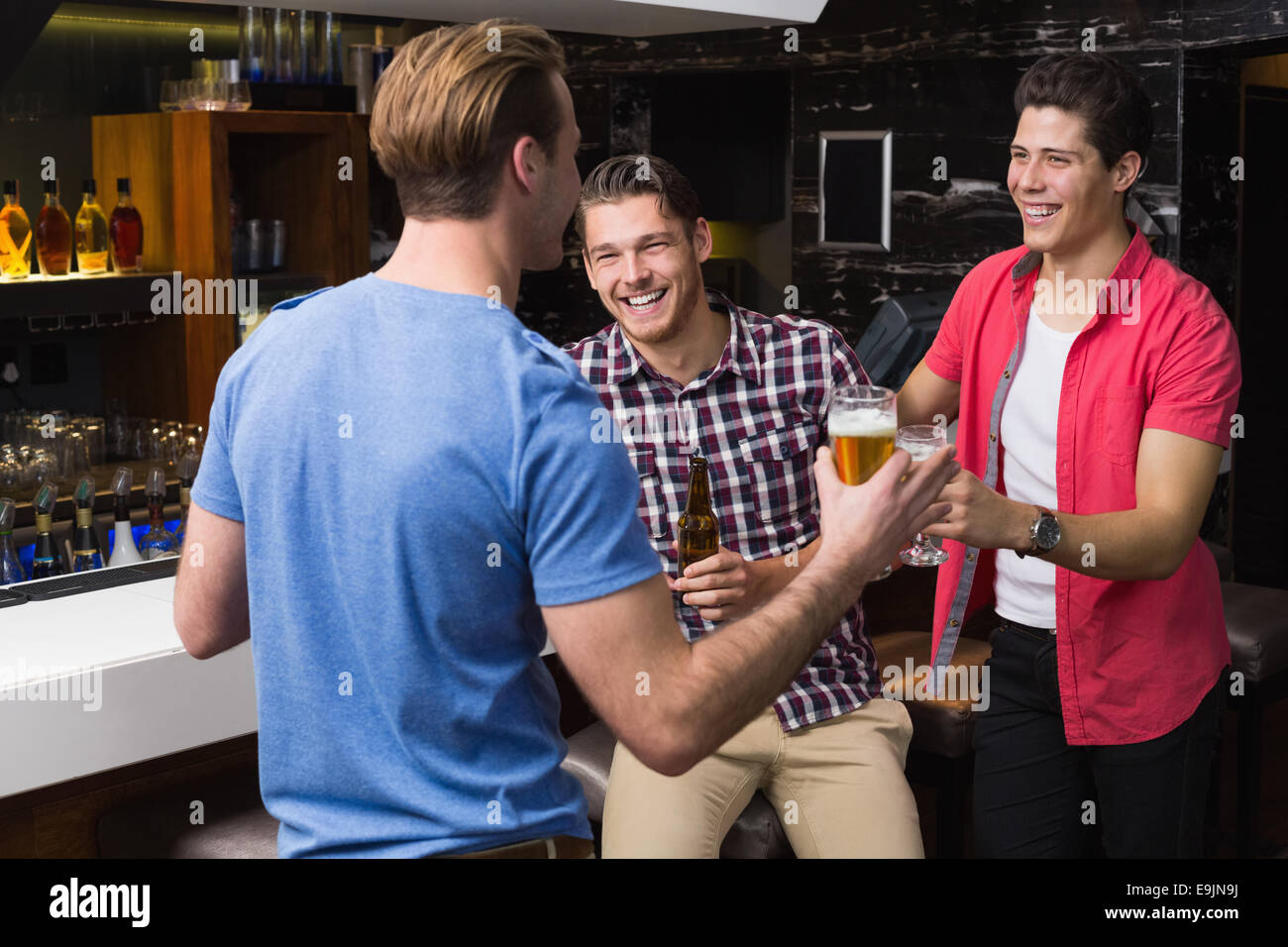 Young men drinking beer together Stock Photo - Alamy