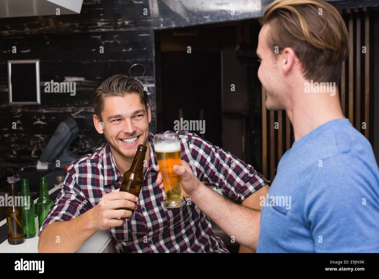 Young men drinking beer together Stock Photo - Alamy