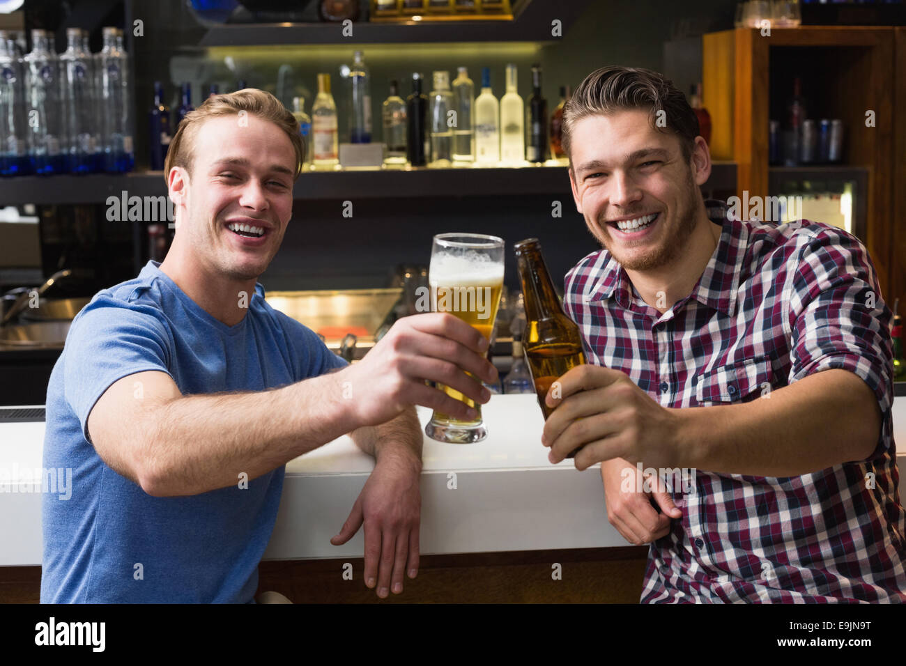 Young men drinking beer together Stock Photo - Alamy