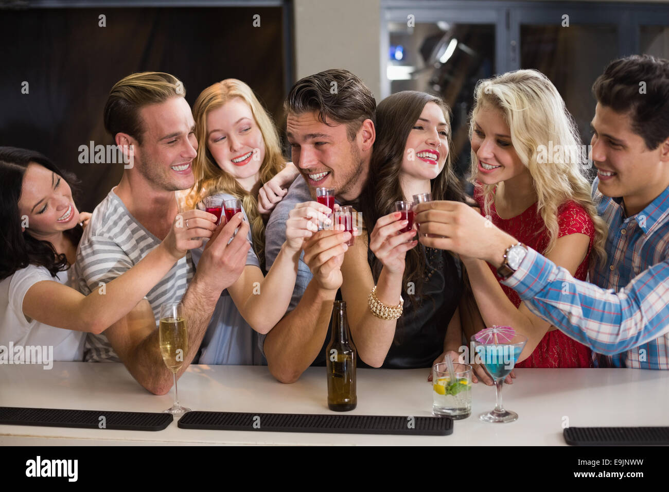 Happy friends having a drink together Stock Photo - Alamy