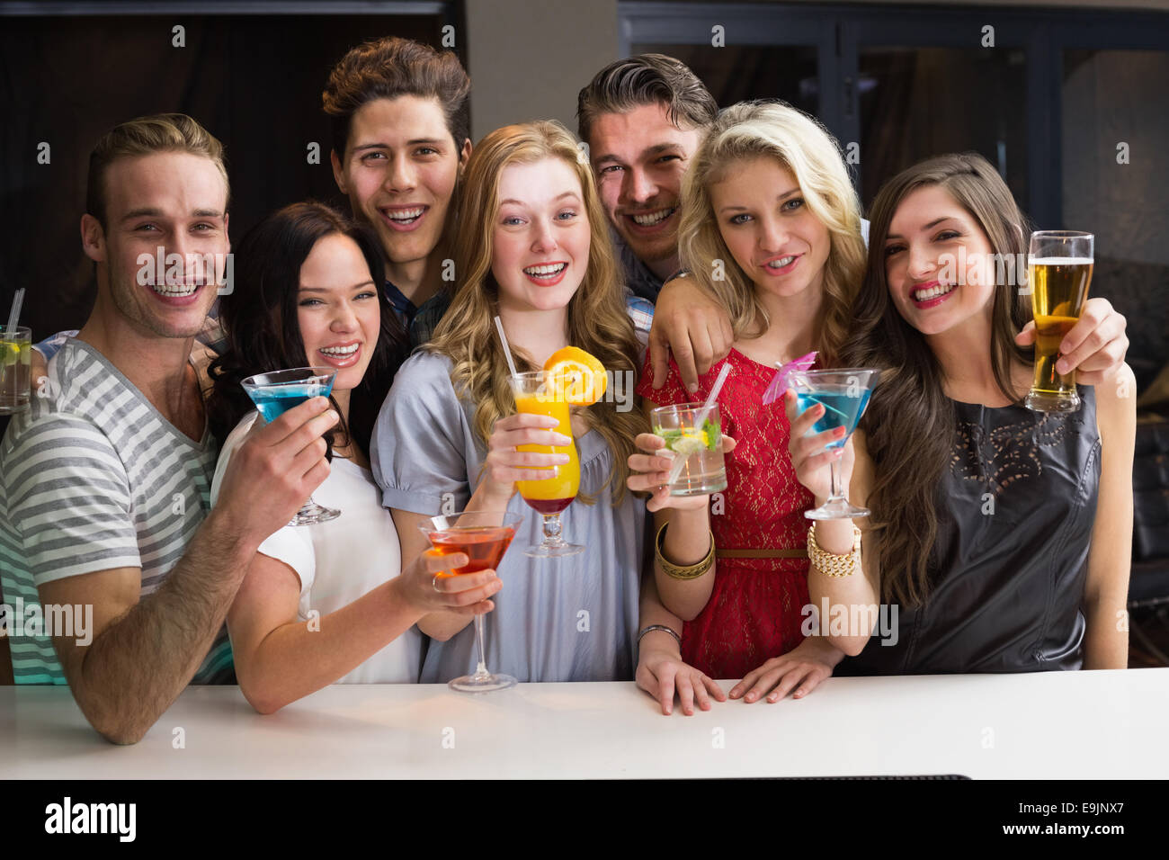 Happy friends having a drink together Stock Photo - Alamy
