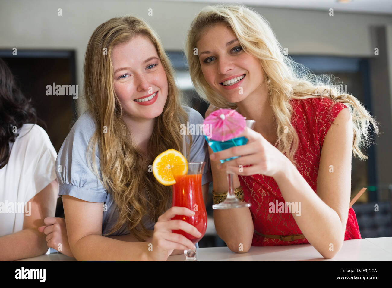 Pretty friends drinking cocktails together Stock Photo - Alamy