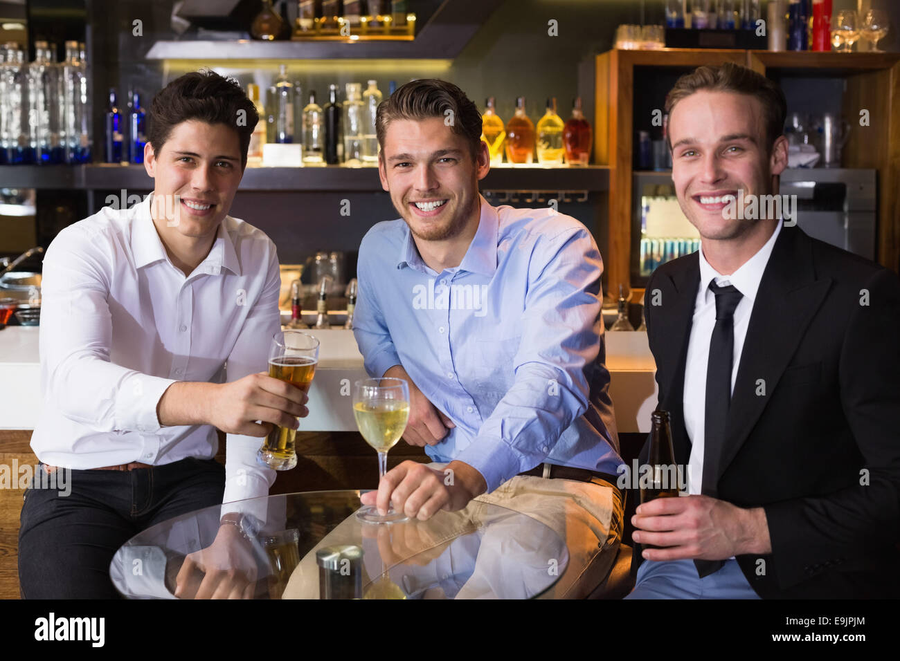 Handsome friends having a drink together Stock Photo - Alamy