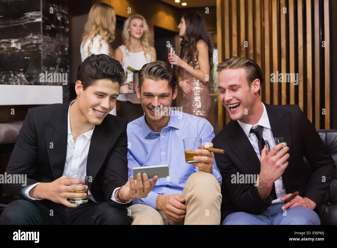 Handsome friends having a drink together Stock Photo - Alamy
