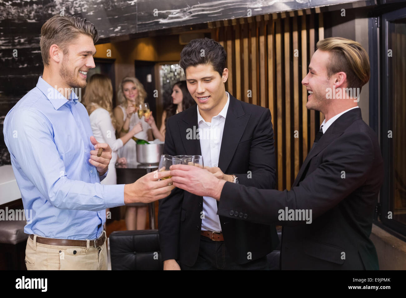 Handsome friends having a drink together Stock Photo - Alamy