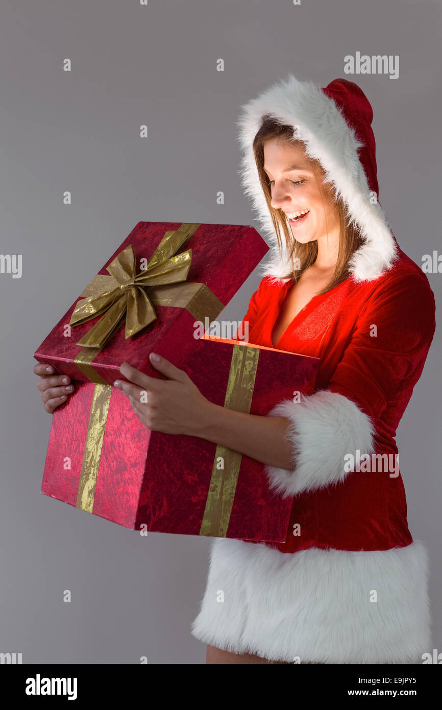 Pretty santa girl opening a gift Stock Photo - Alamy