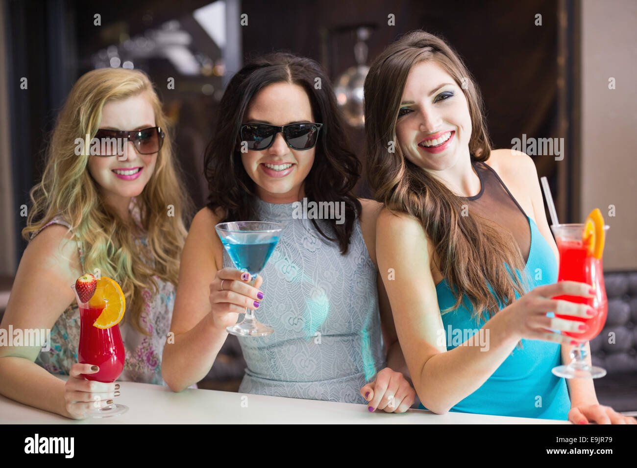 Attractive friends drinking cocktails together Stock Photo - Alamy